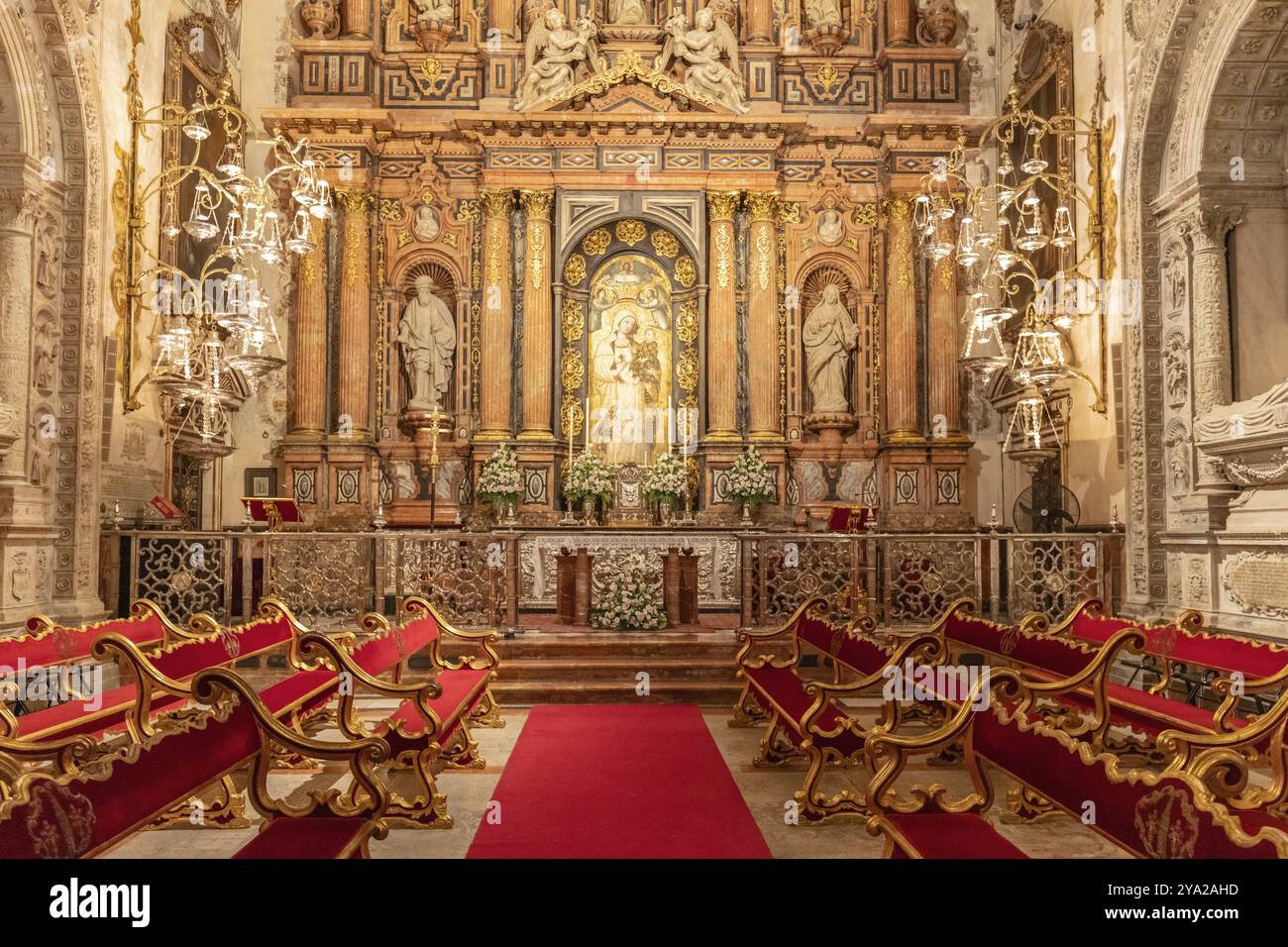 Opulent chapel with magnificent altar and elegant red benches, Seville ...