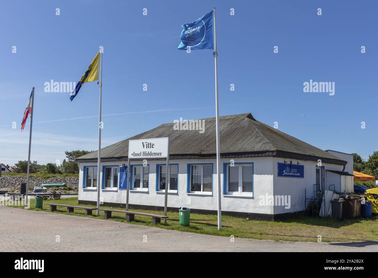 Small historic building with waving flags under a blue sky in sunny ...