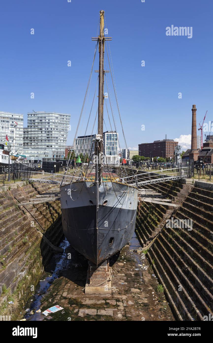 Old sailing ship in the harbour basin against a backdrop of modern ...