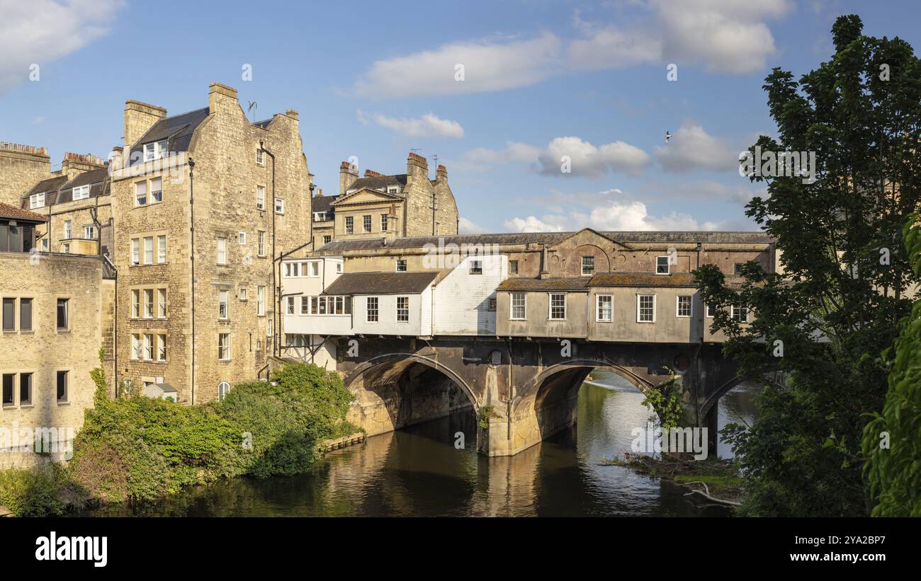 Historic bridge connects old brick buildings by the river, Bath Stock ...
