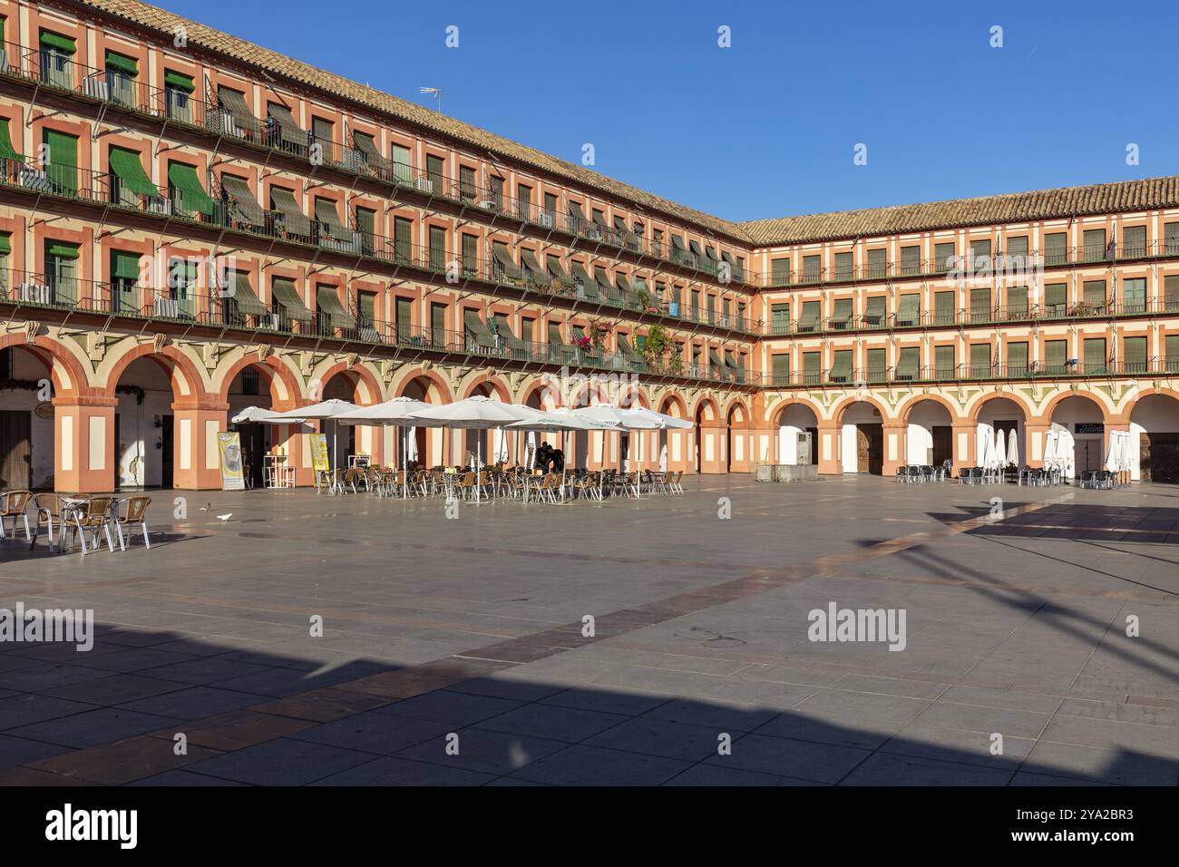 Wide plaza with arcades and empty cafe chairs, traditionally designed ...