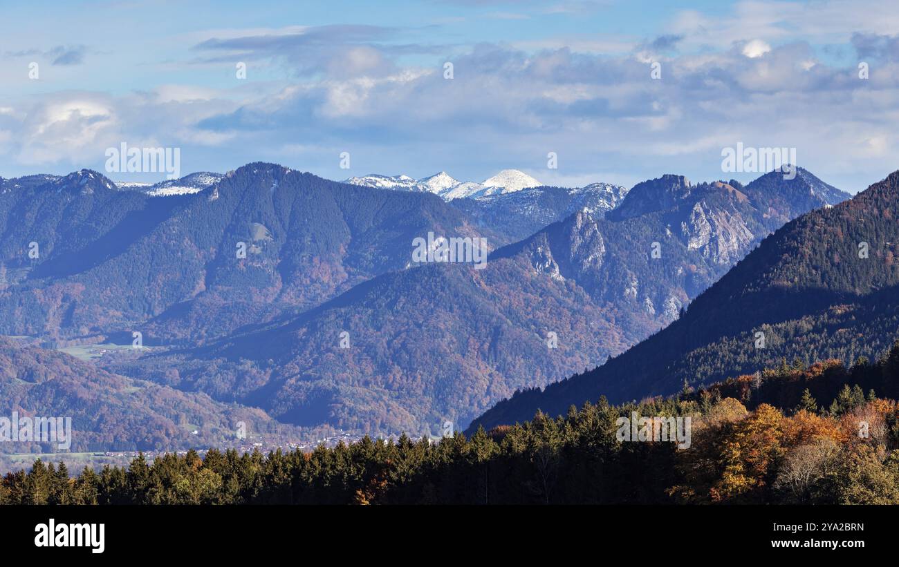 Mountain panorama with snow-covered peaks and autumnal forest in the ...