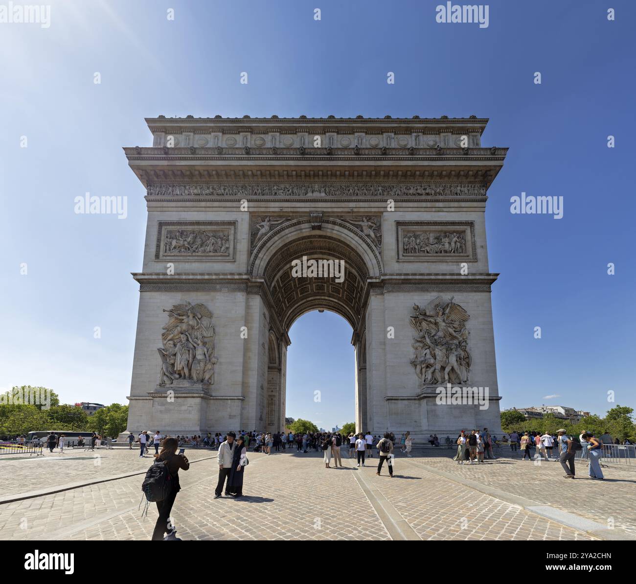 Front view of the Arc de Triomphe, people walking under the sunny sky ...