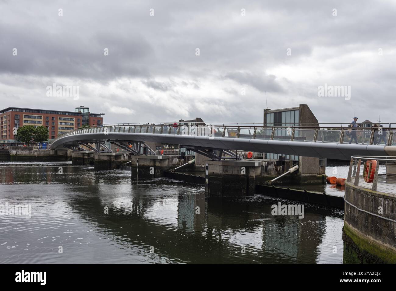 Modern designed bridge spanning a river under a cloudy sky, Belfast ...