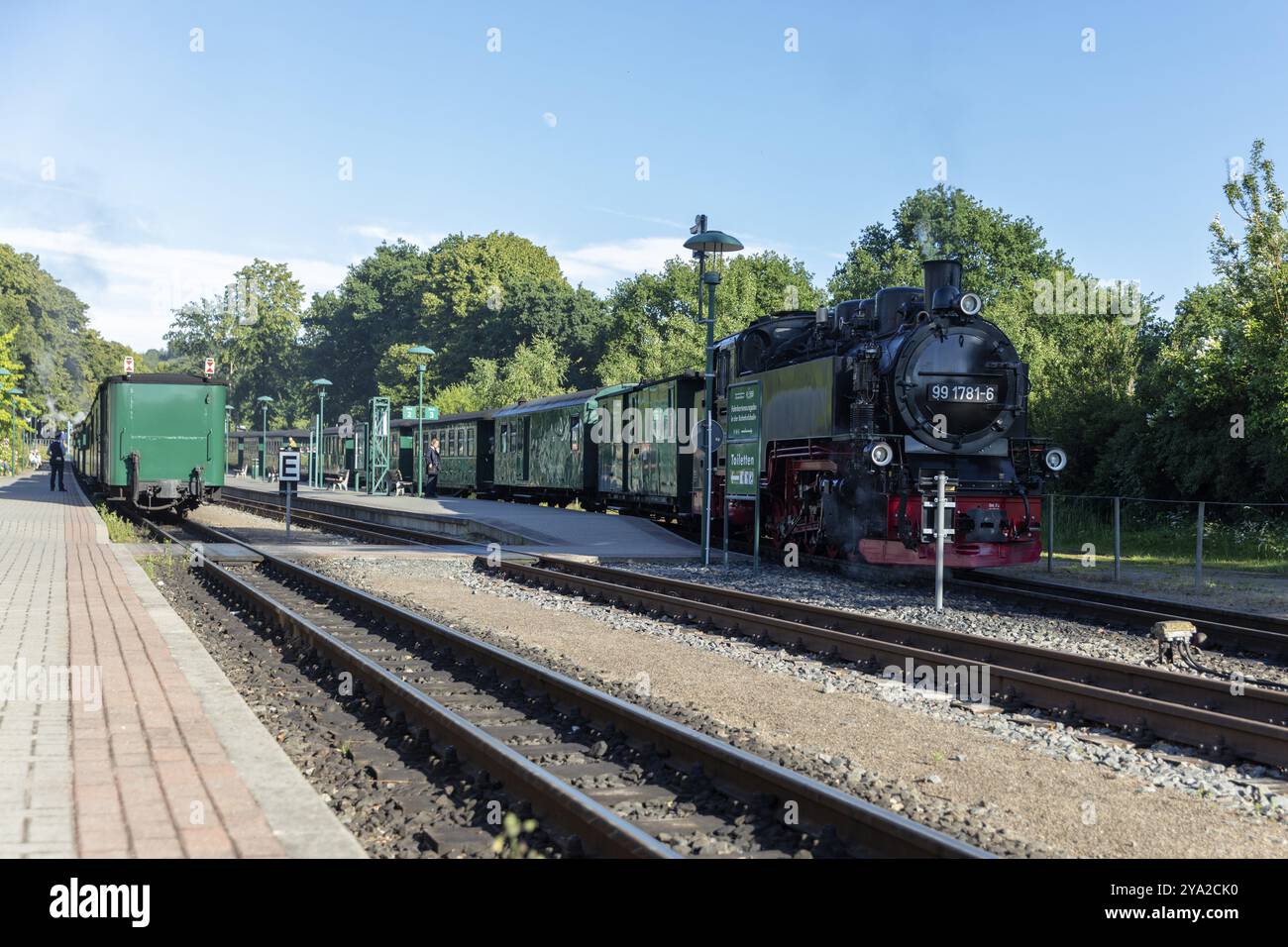 Historic train with steam locomotive at the railway station, surrounded ...
