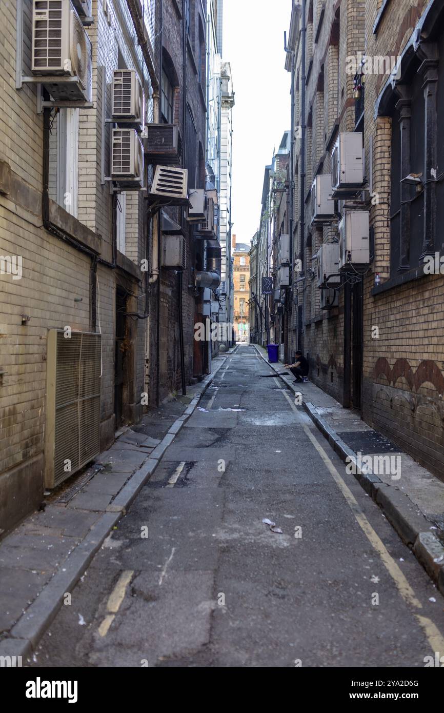 Narrow, functional alleyway between air-conditioned brick walls ...