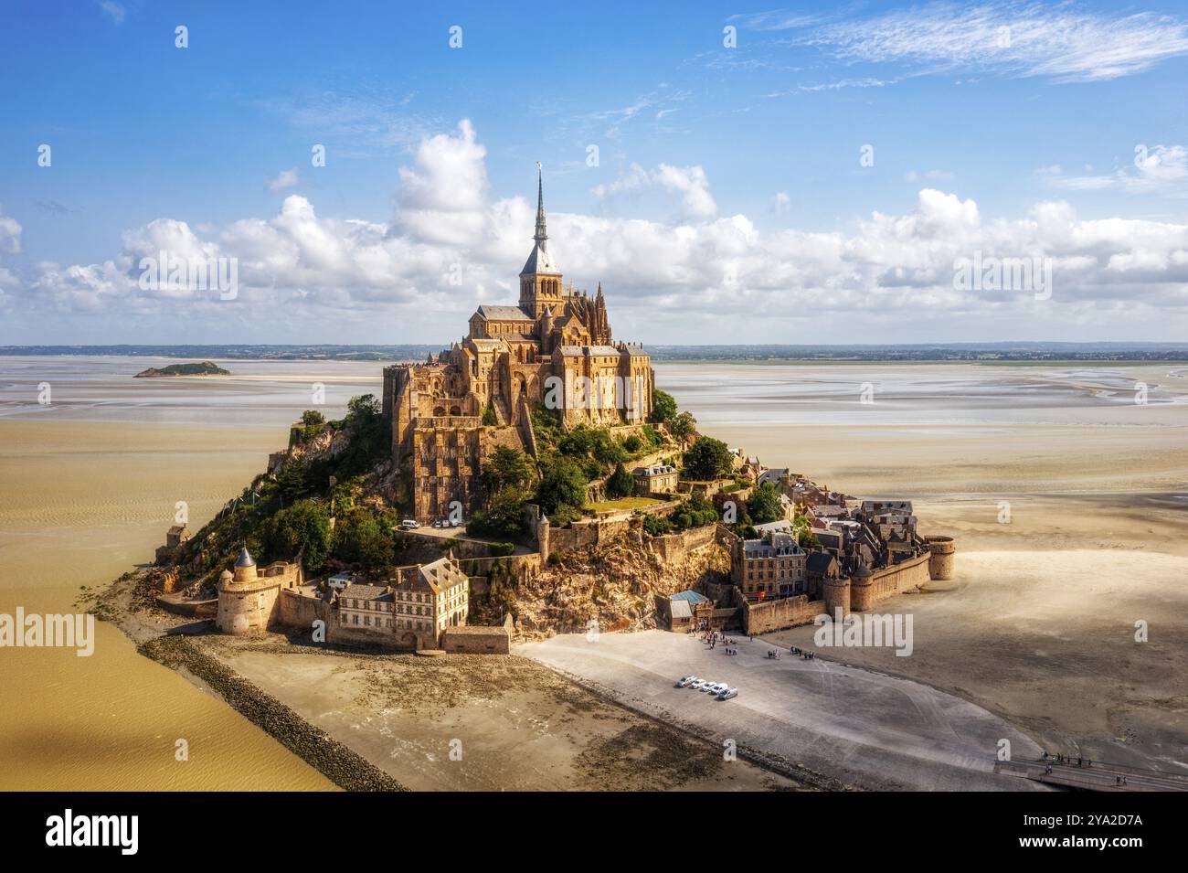 High-lying abbey on a rocky island, surrounded by sand and blue sky, Le ...
