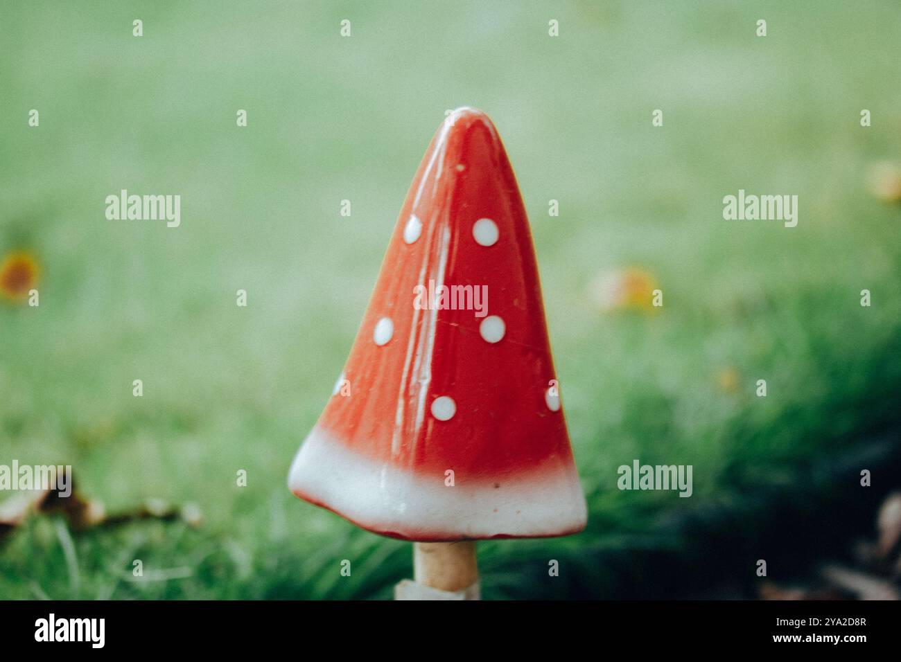 Decorative red fly mushroom in a white dot on a green lawn. Decor for ...