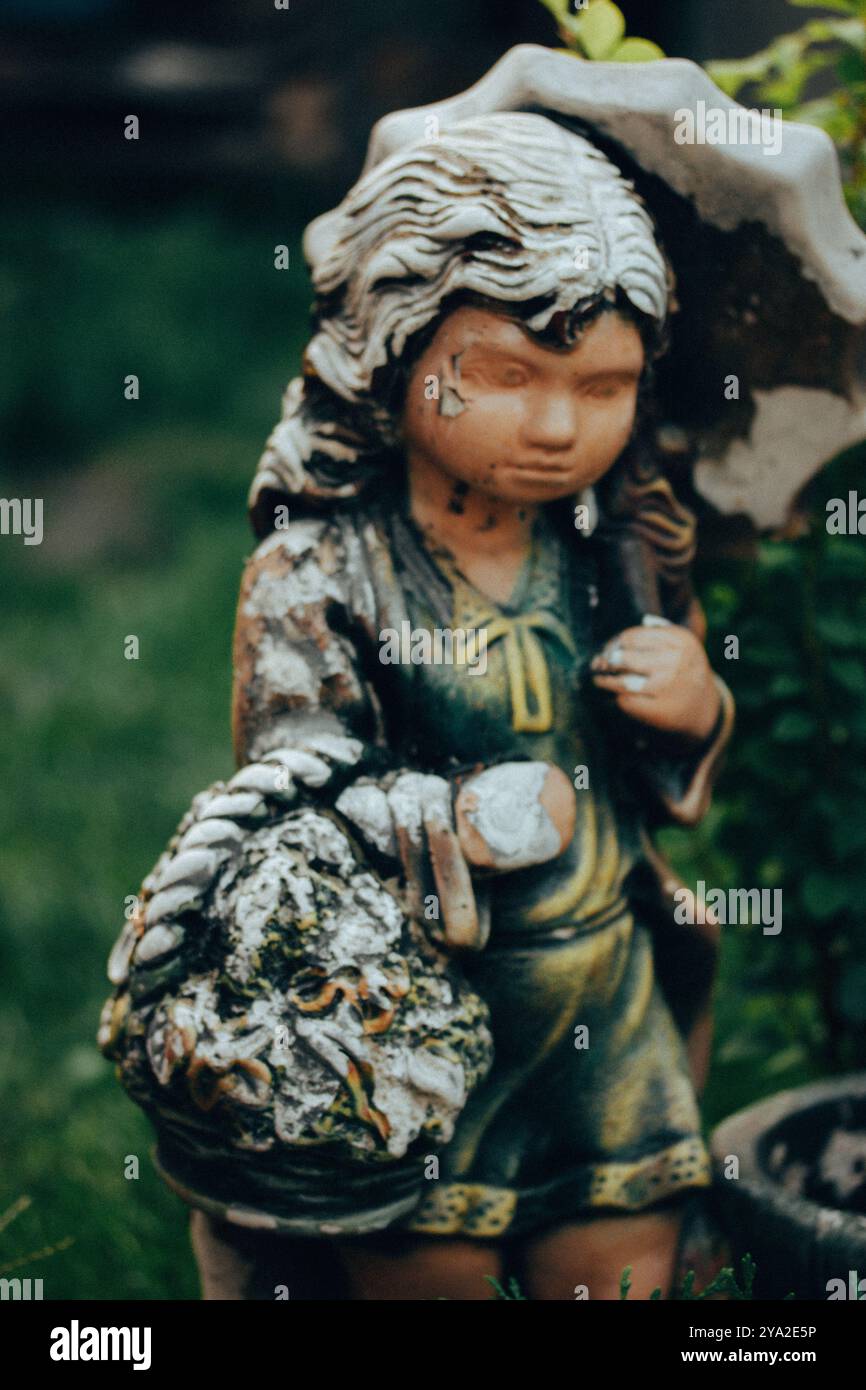 Worn stone angel. Vintage female figurine with shabby paint on her face ...