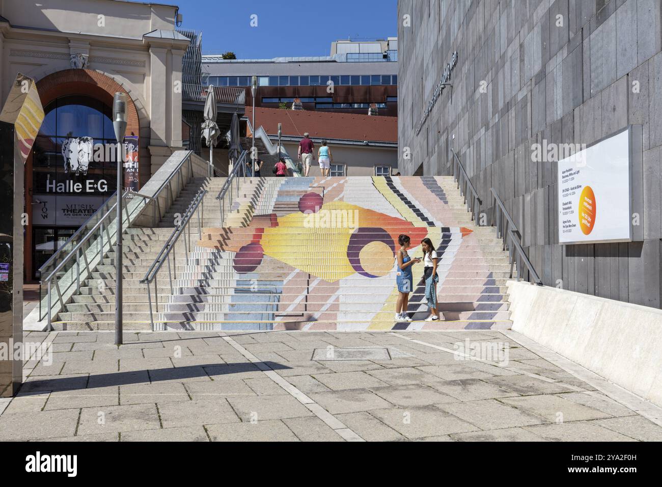 Colourful art installation on stairs, animated by people, in an urban ...