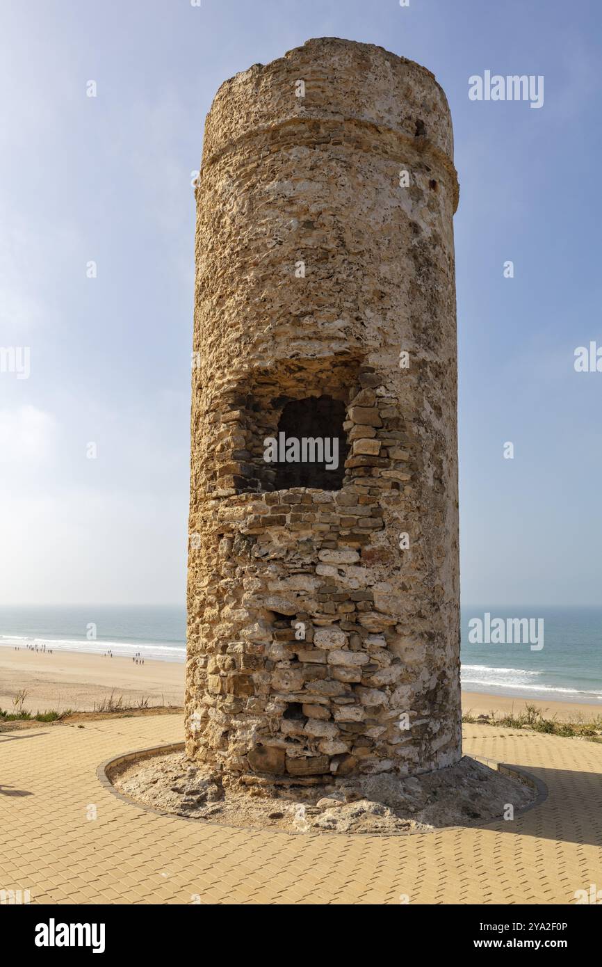 An old stone tower stands isolated on the beach with a view of the vast ...