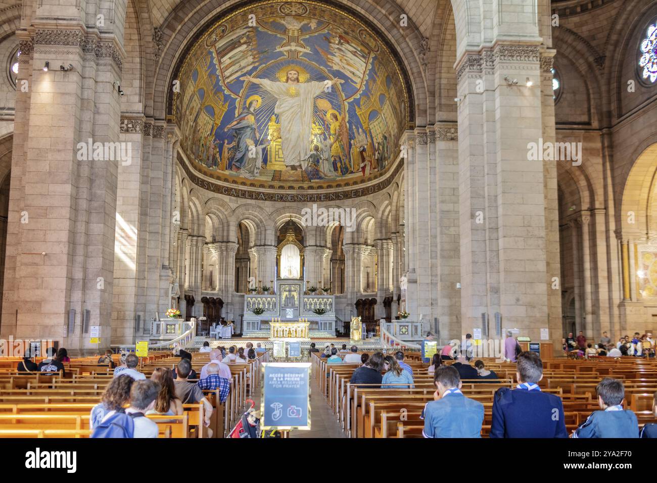 Church interior with a large mosaic of Jesus above the altar, people ...