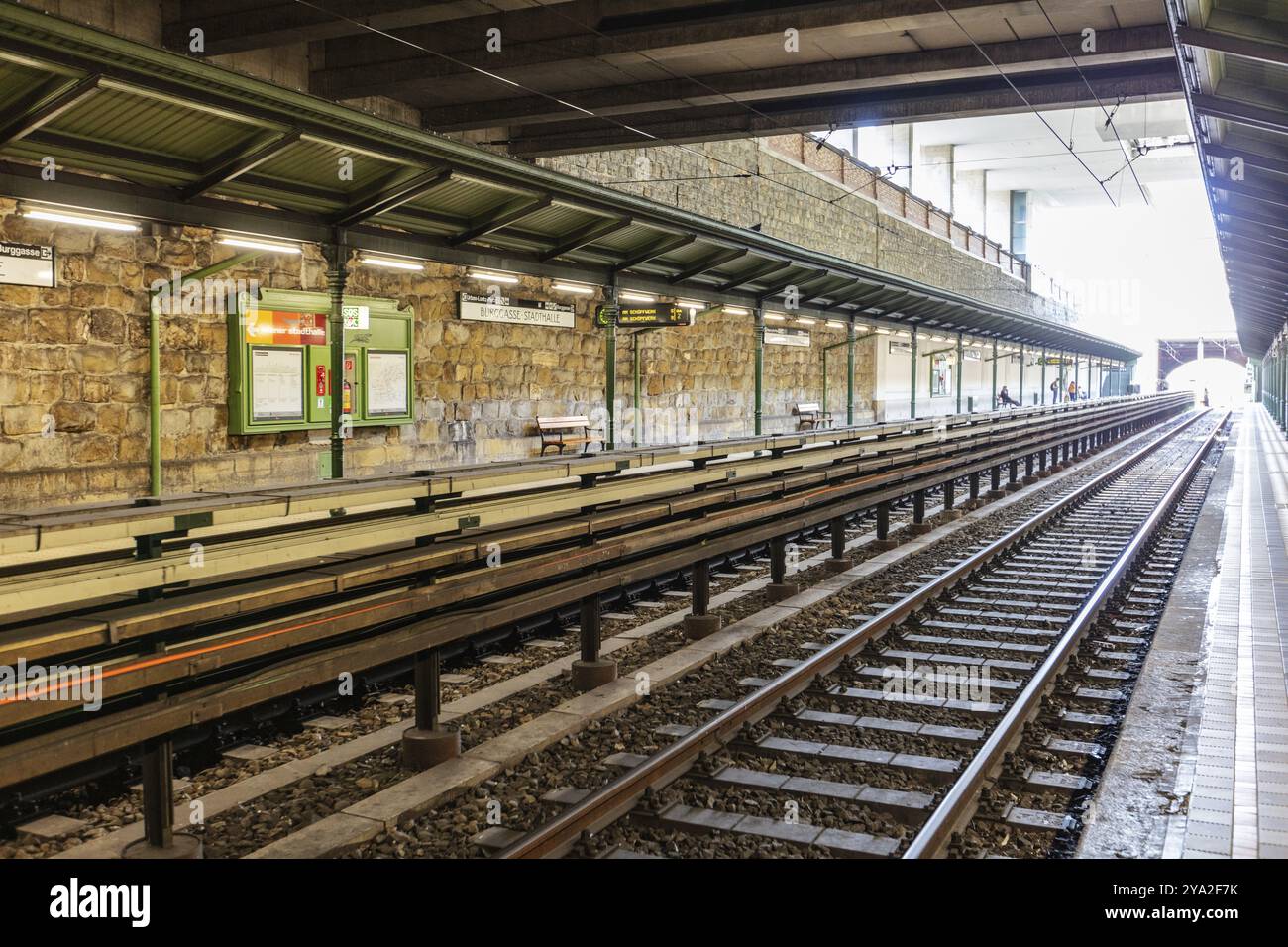 Underground station with empty tracks and covered platforms, light and ...