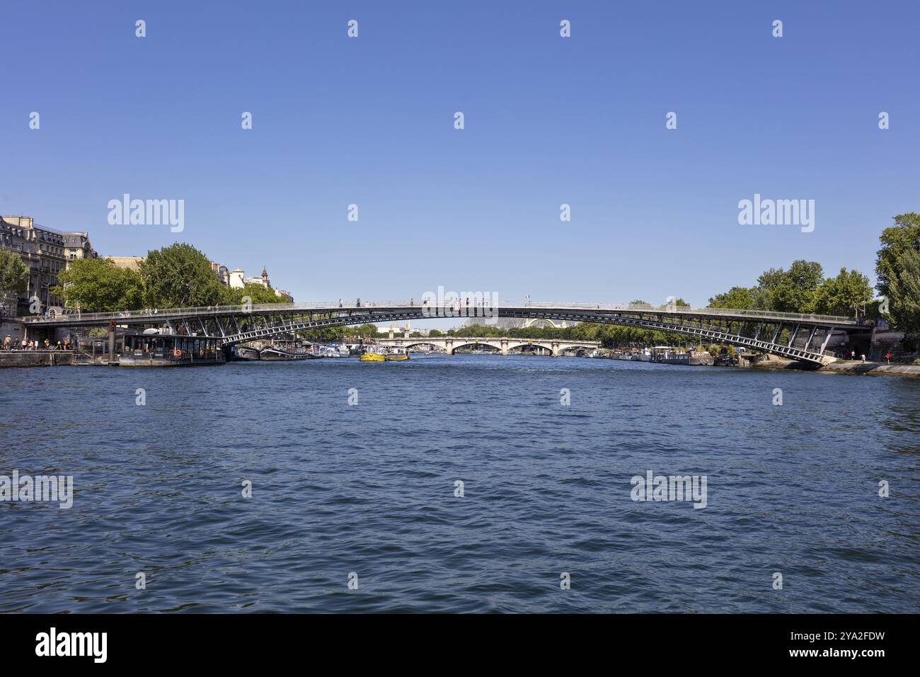 Modern bridge over a river with urban surroundings and natural backdrop ...