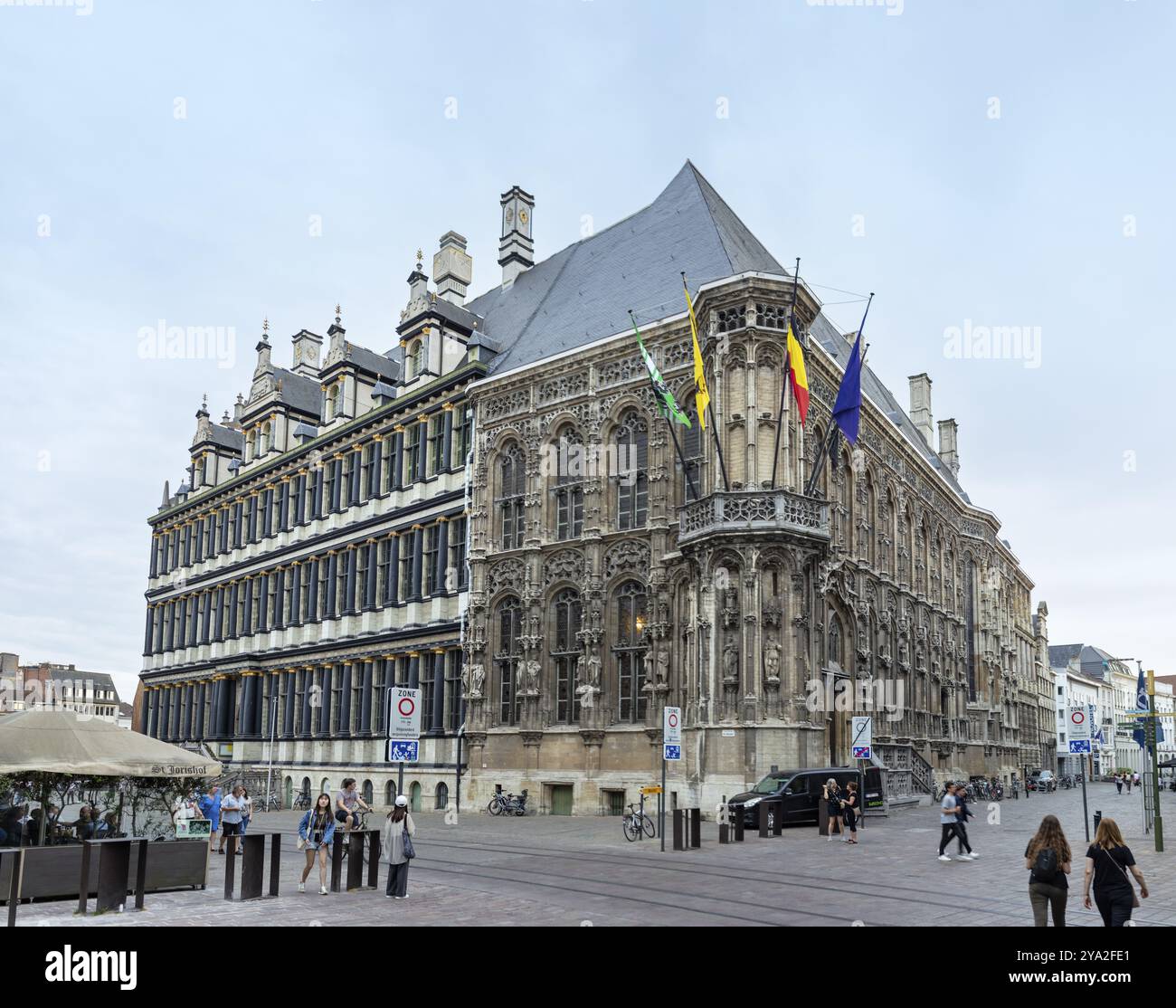 Majestic historic building with Gothic architecture and waving flags ...