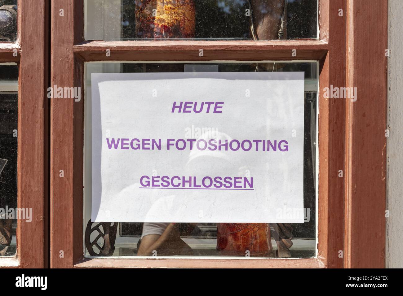 Closed shop with sign due to photo shoot in wooden frame window, Vienna ...