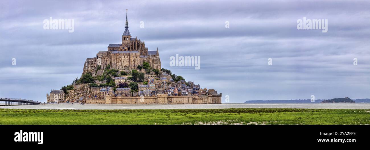 Mont Saint-Michel towers majestically on an island under a cloudy sky ...
