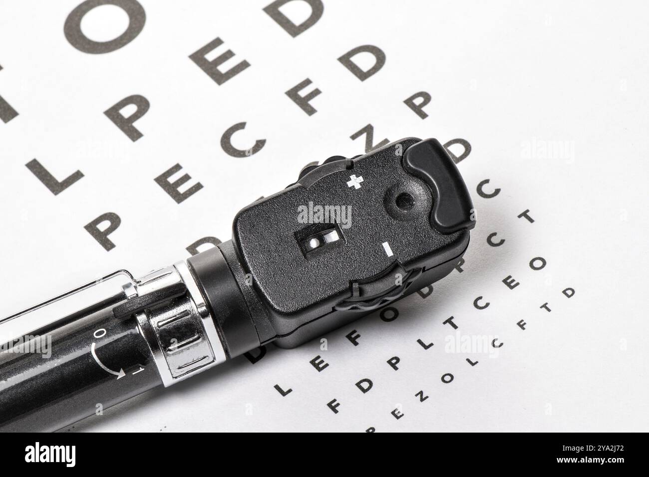 The ophthalmoscope is located on an eye test, with a white background ...