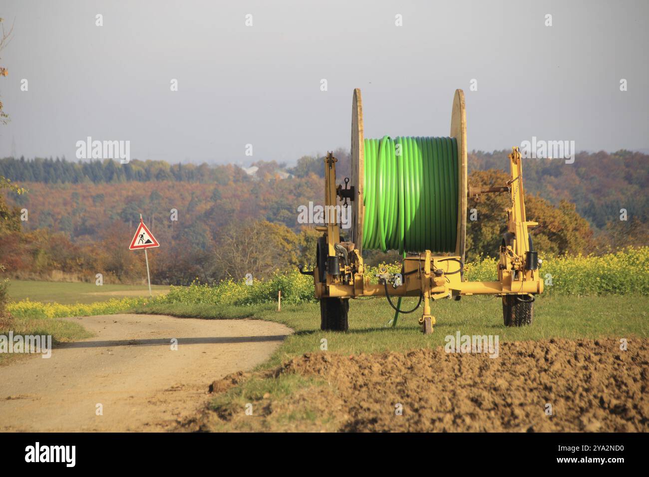 Trailer with a roll of empty conduit for laying cables in the ground ...