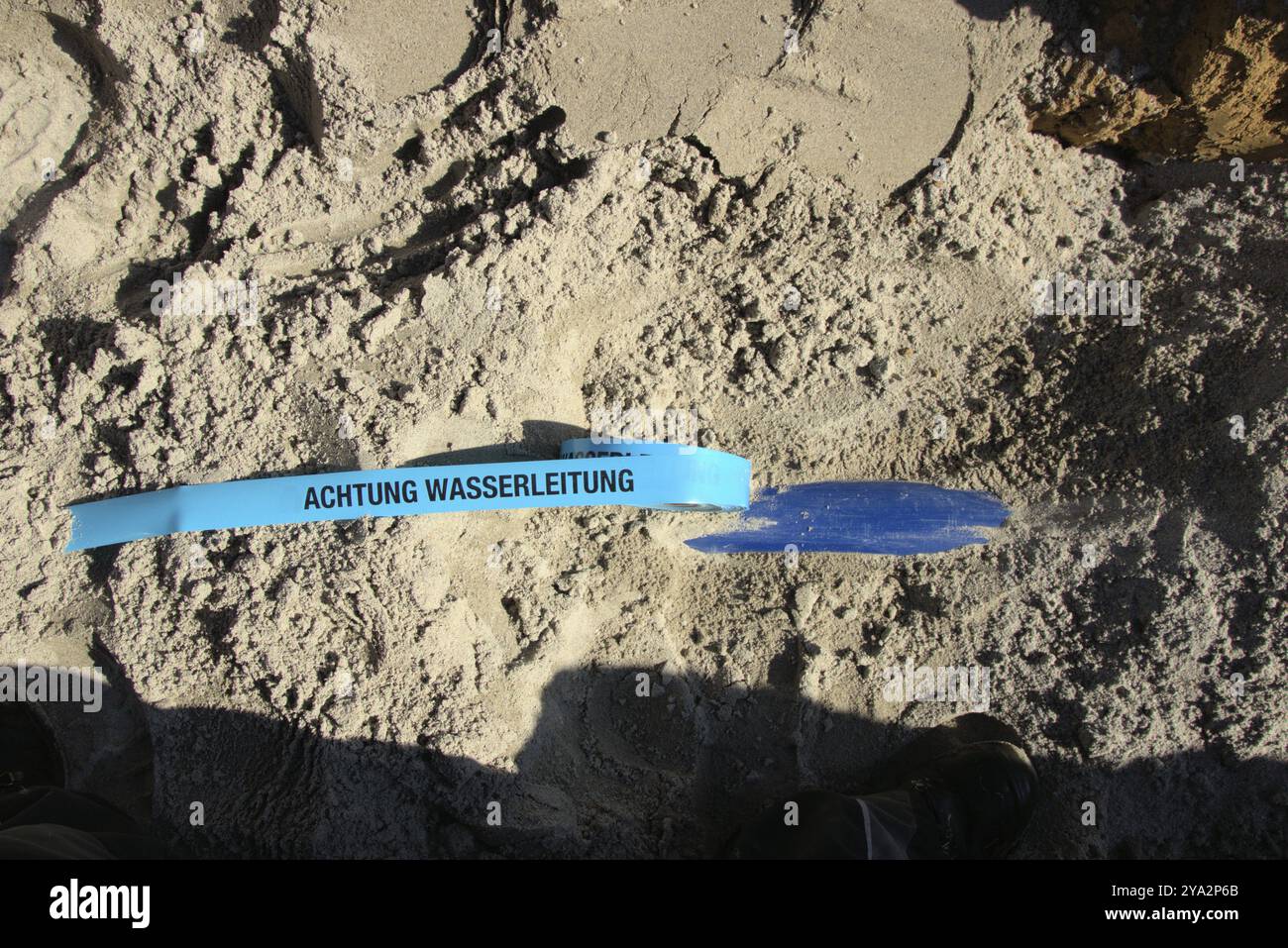 Indicator tape for a water pipe in an excavation pit Stock Photo - Alamy