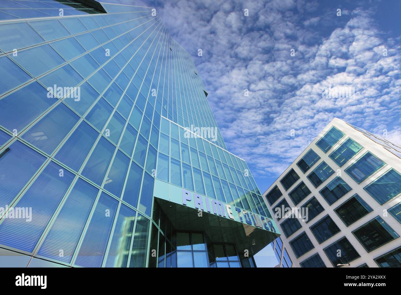 The impressive Prime Tower with clouds in the sky and modern structures ...