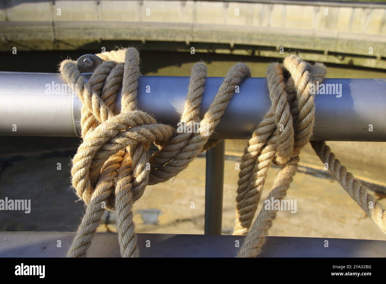Thick ropes were attached to a pipe with knots Stock Photo - Alamy
