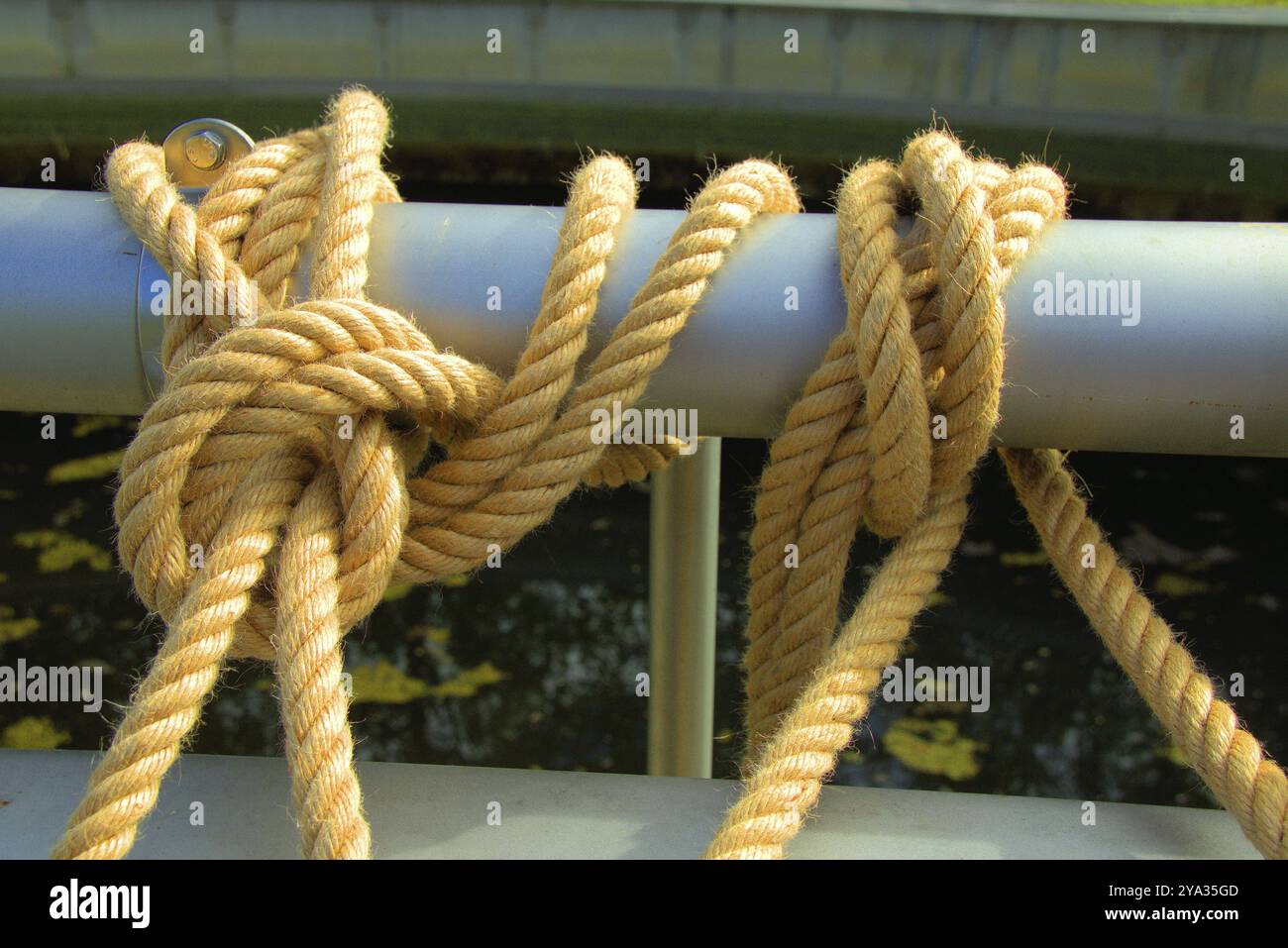 Thick ropes were attached to a pipe with knots Stock Photo - Alamy