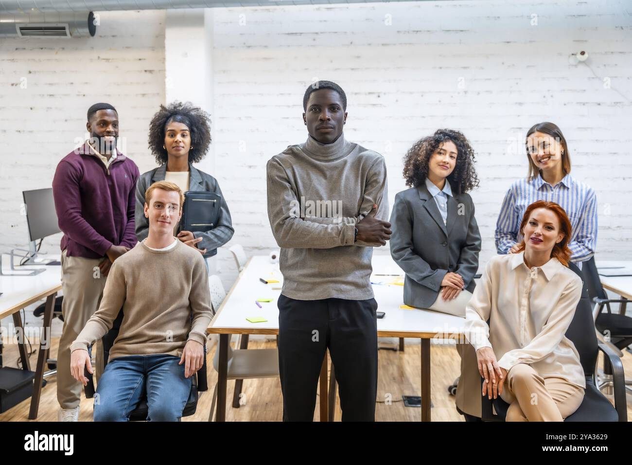 Portrait of an african man standing next to coworking colleagues ...