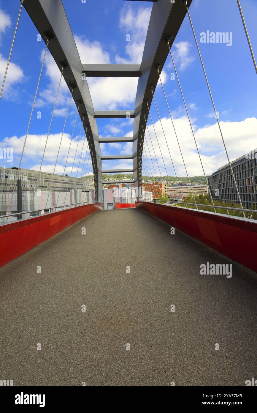 Steel bridge in an urban setting with blue sky and clouds, pedestrian ...