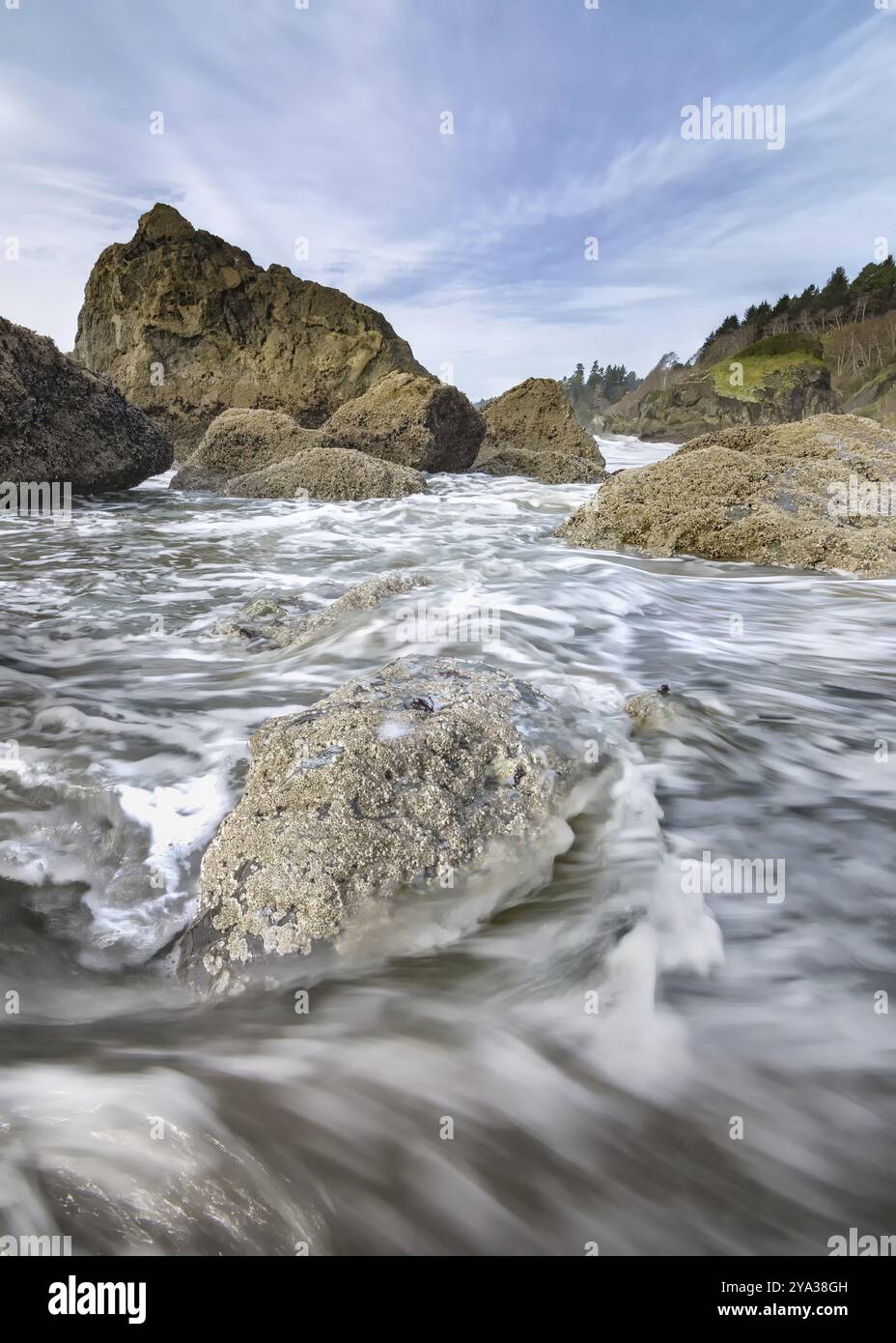 This is a color landscape photo of the Pacific Ocean at a rocky beach ...