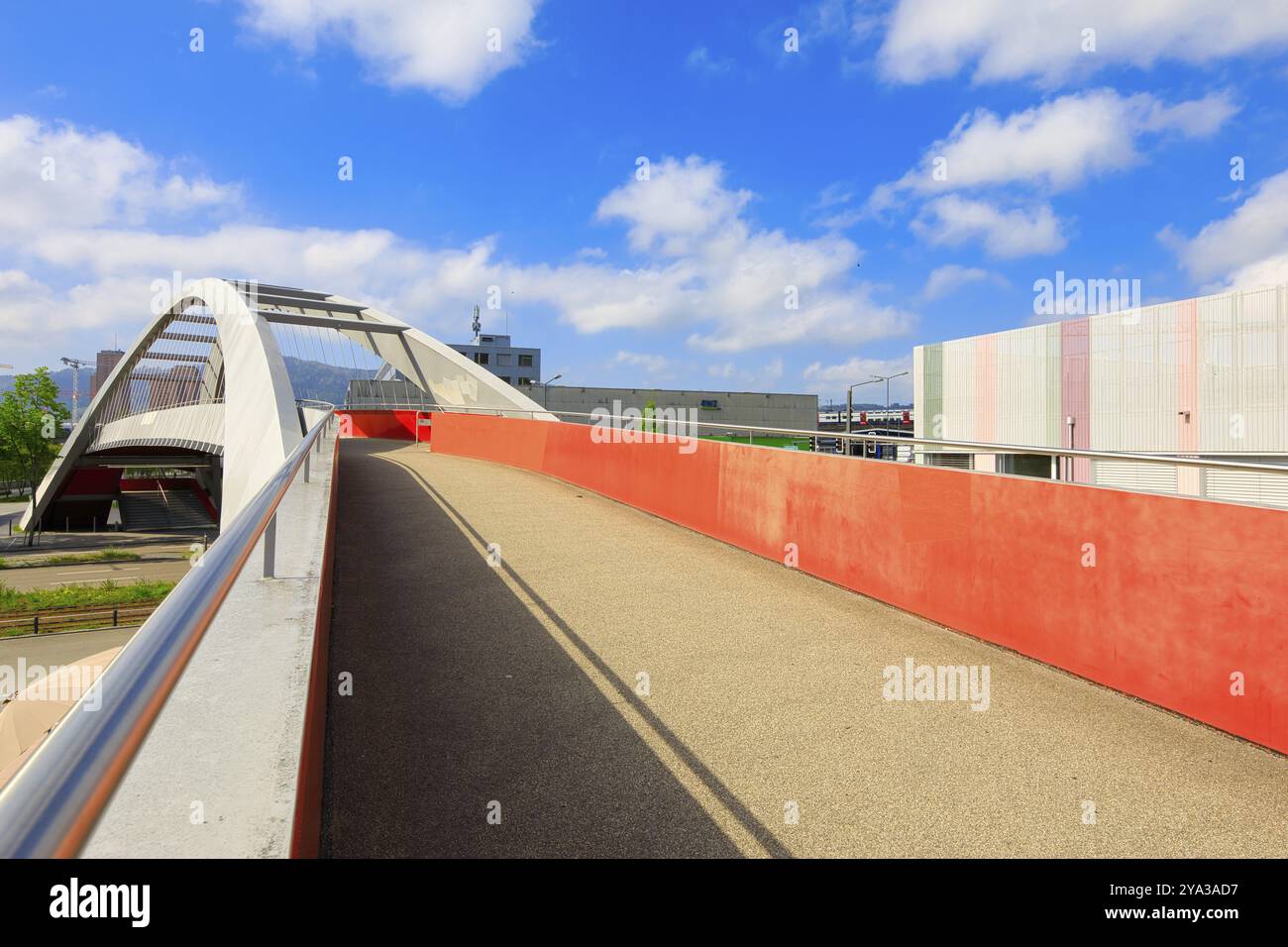 Modern bridge with red elements under a blue sky in an urban ...
