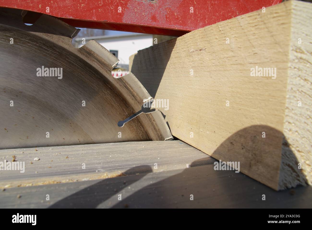 A piece of timber rests against the saw blade of a circular saw Stock ...