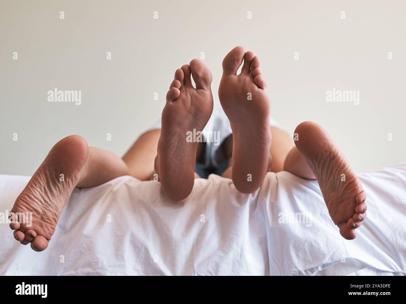 Relax, cuddle and feet of couple in bedroom for bonding, hotel getaway ...