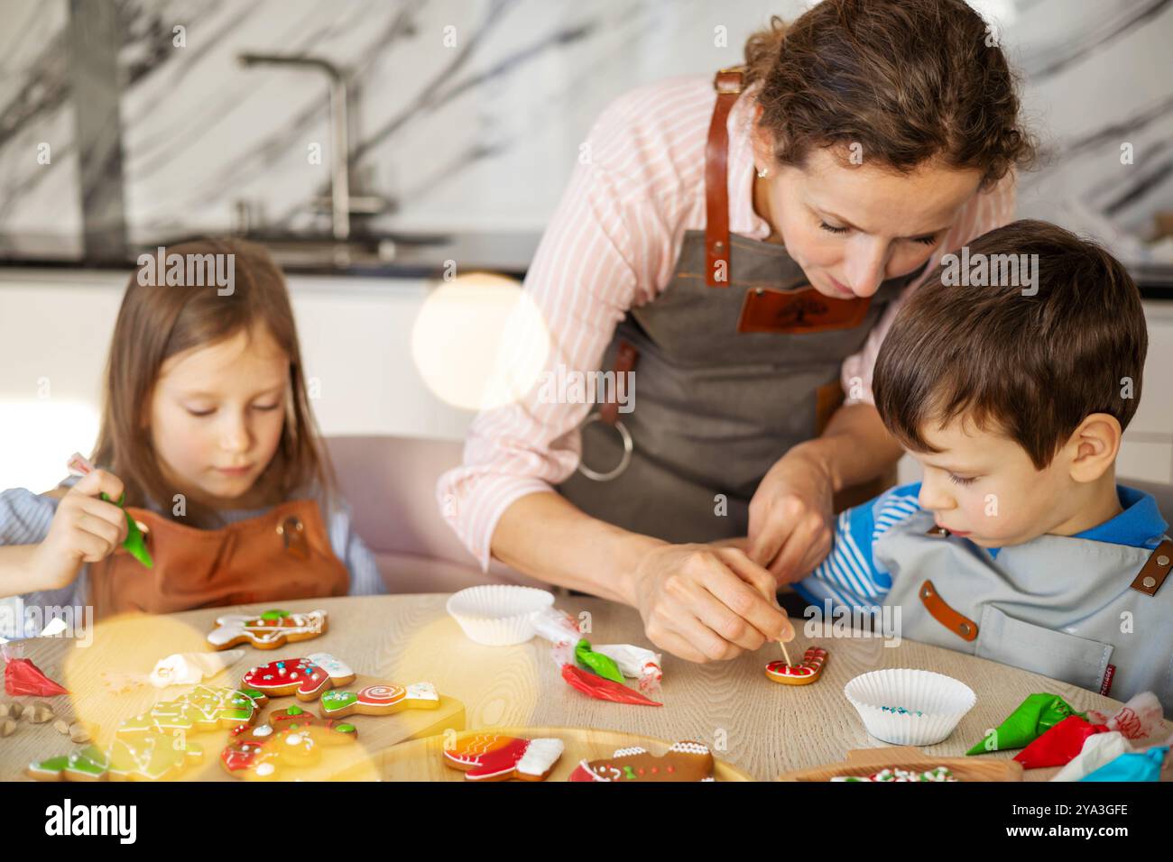 Happy family mother and children in aprons making Christmas cookies ...