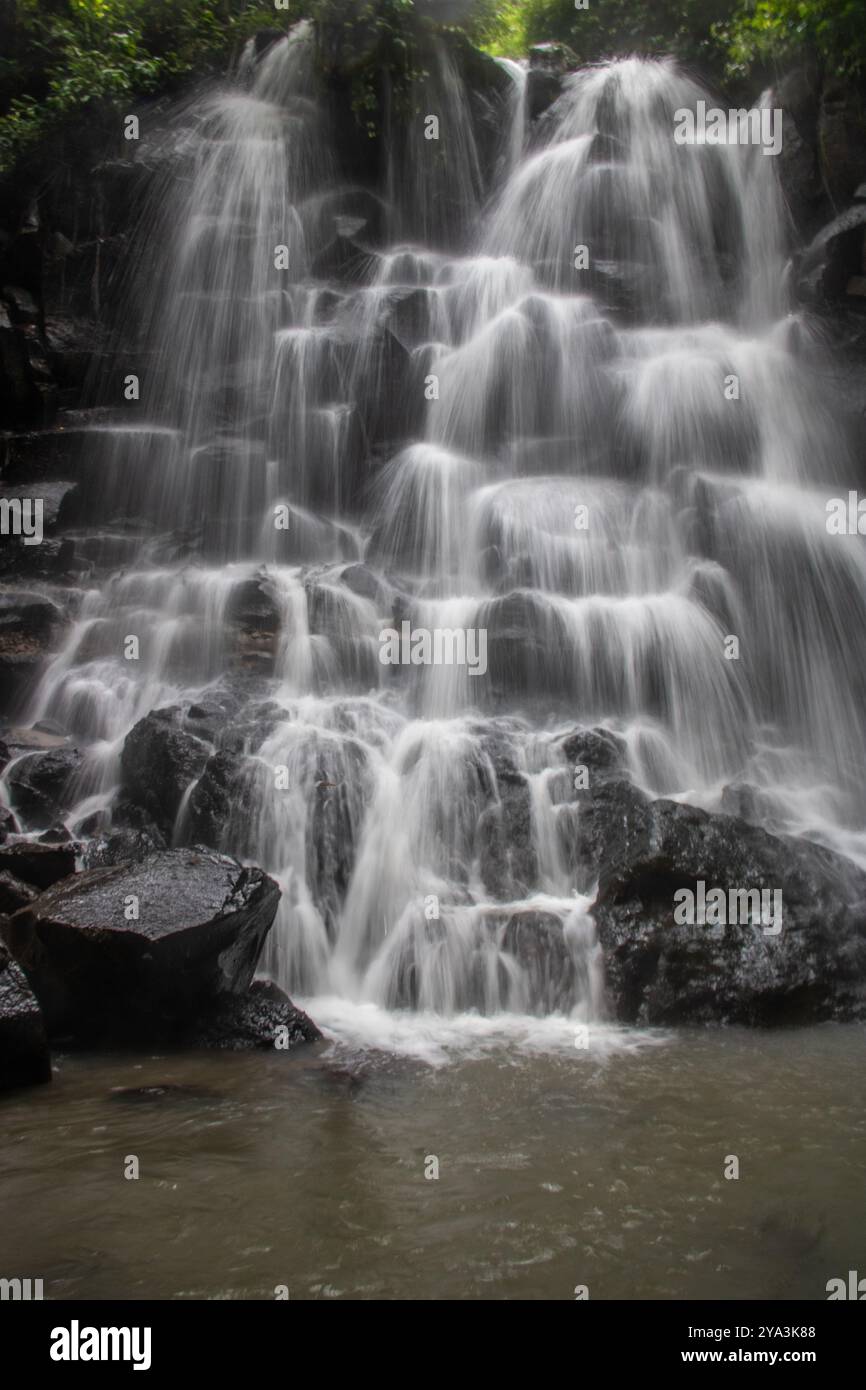Beautiful hidden waterfall falling over multiple levels. surrounded by ...