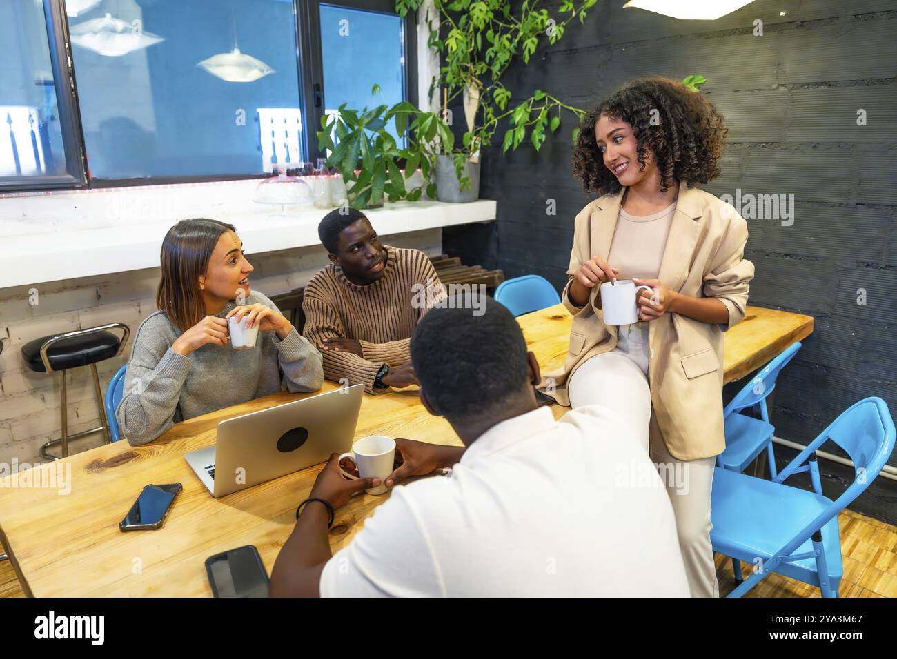 Happy coworkers talking together during coffee break in the canteen of ...