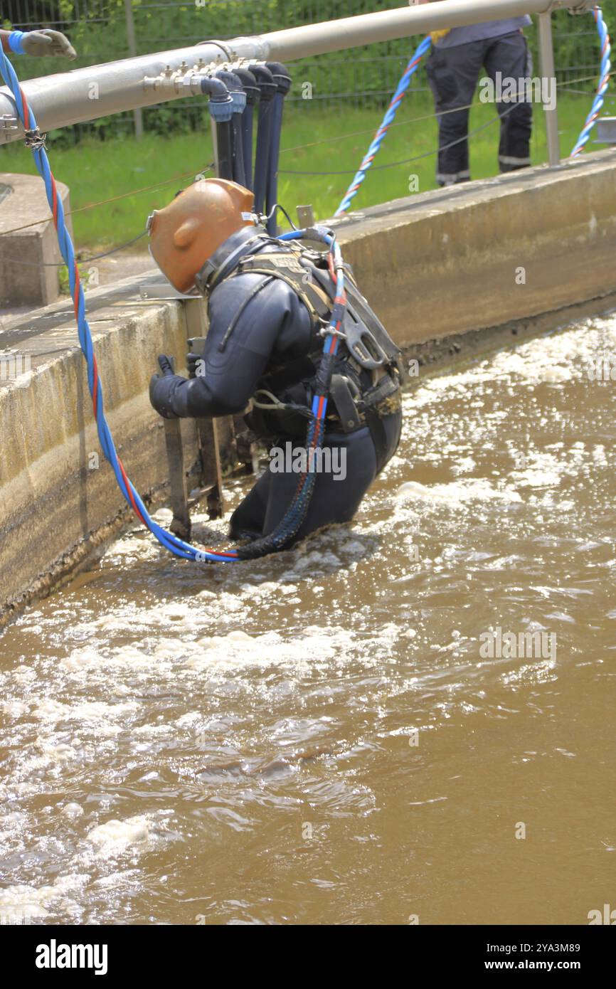 Diver climbs into the aeration tank at a sewage treatment plant Stock ...