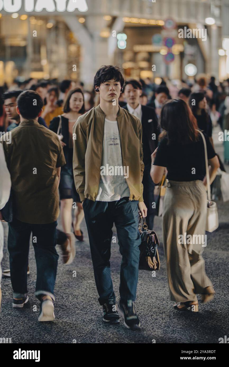 TOKYO, JAPAN, MAY 11, 2019, A man crosses across Shibuya Crossing which ...