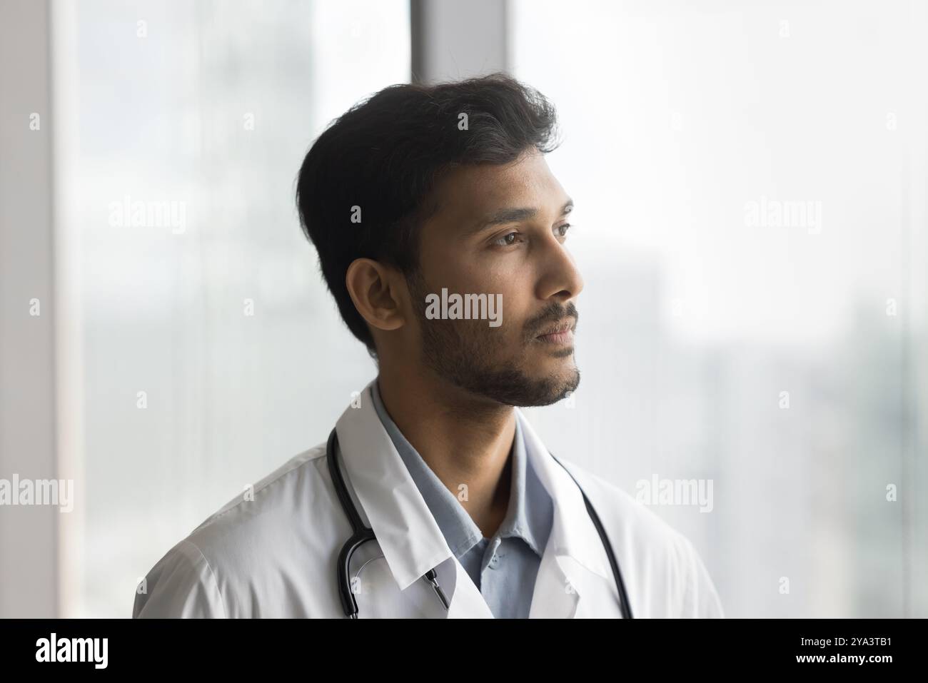 Pensive male doctor stand by window focus on new idea Stock Photo - Alamy