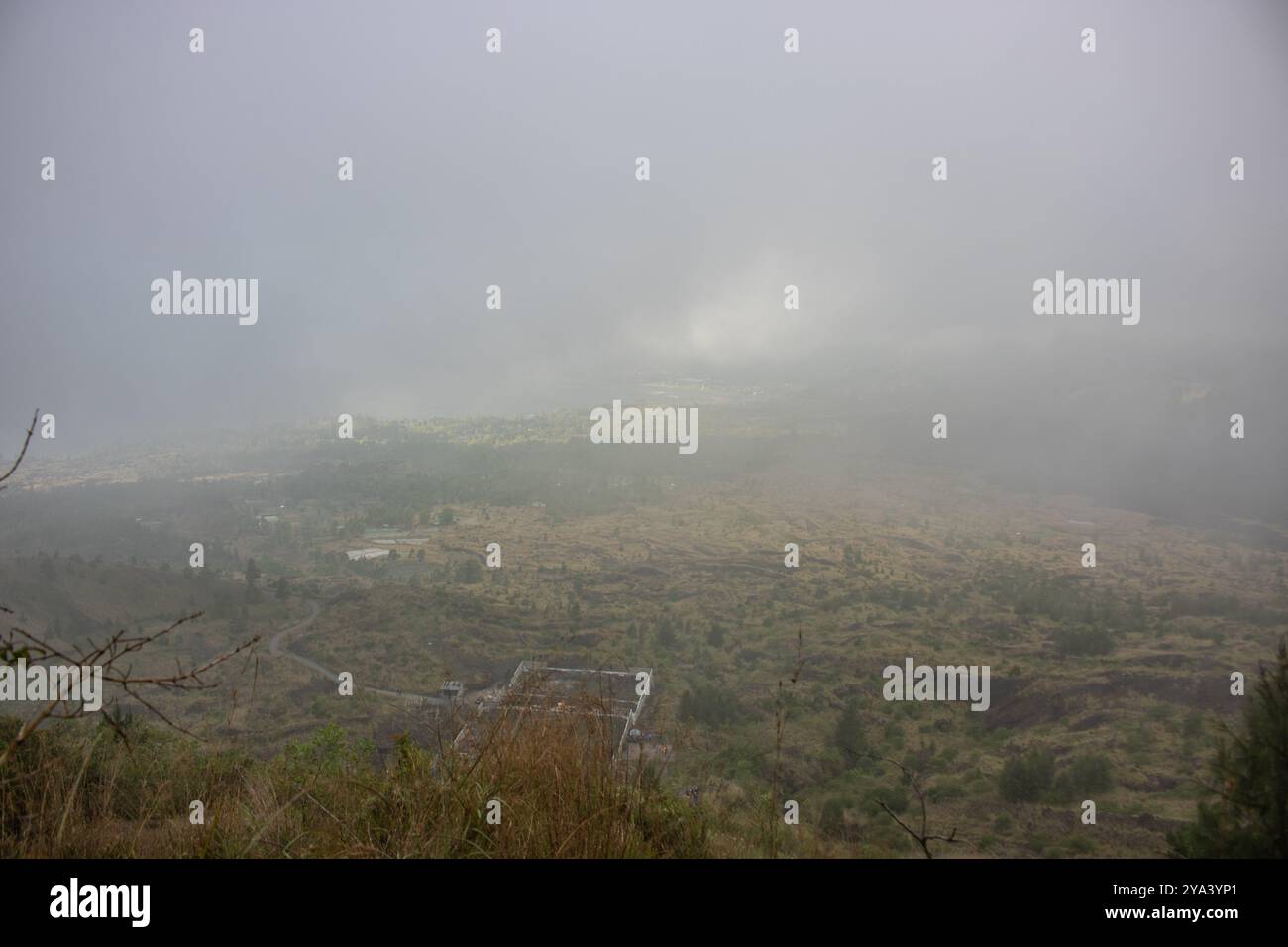Sunrise on a volcano. View above and through the clouds to the rising ...