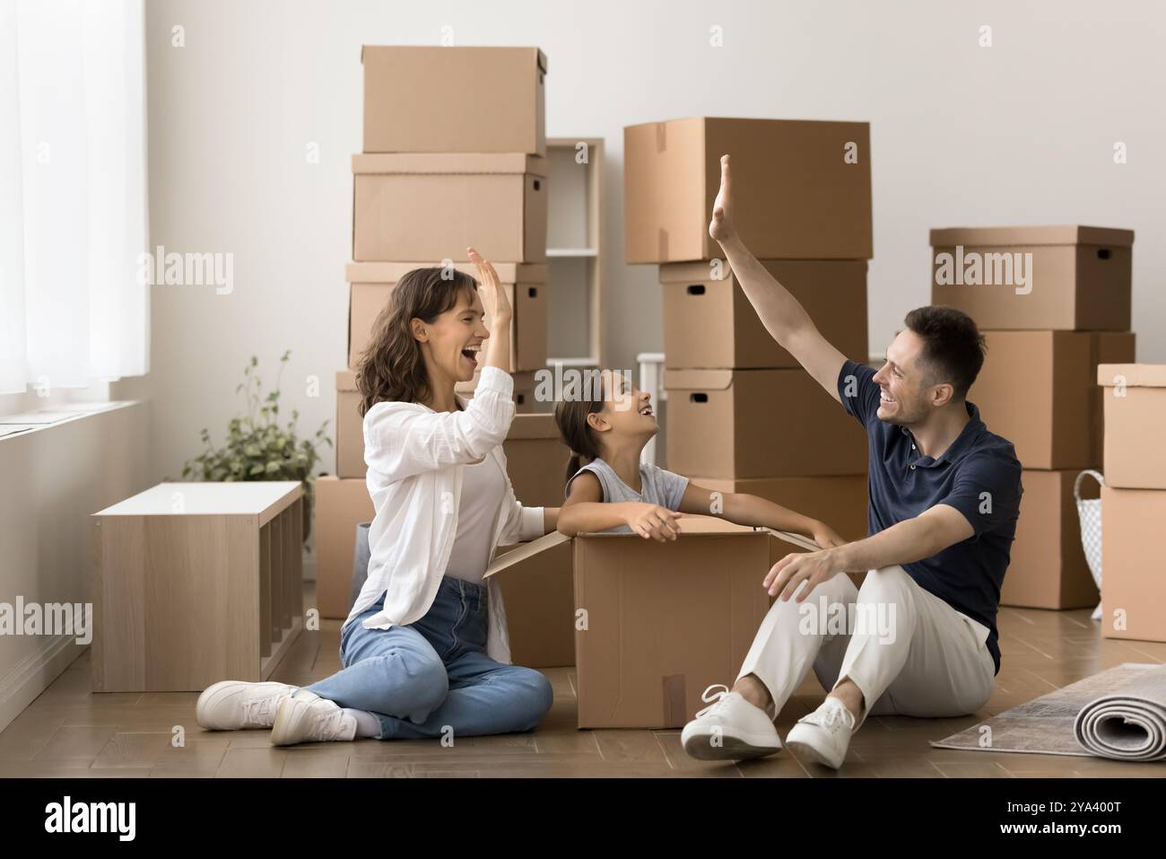 Family moving to new flat making high five unpacking stuff Stock Photo - Alamy