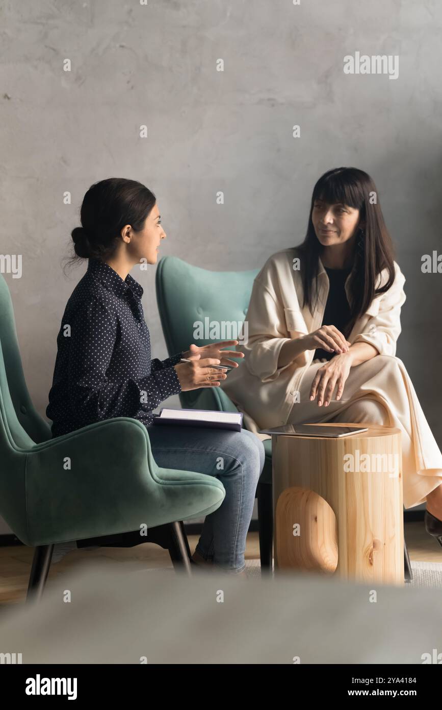 Busy engaged diverse businesswomen discussing project, sitting in ...