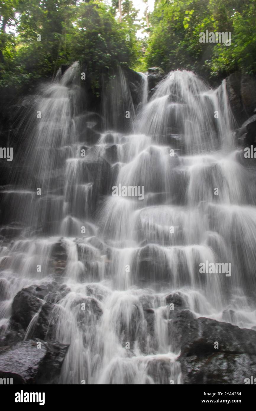 Beautiful hidden waterfall falling over multiple levels. surrounded by ...