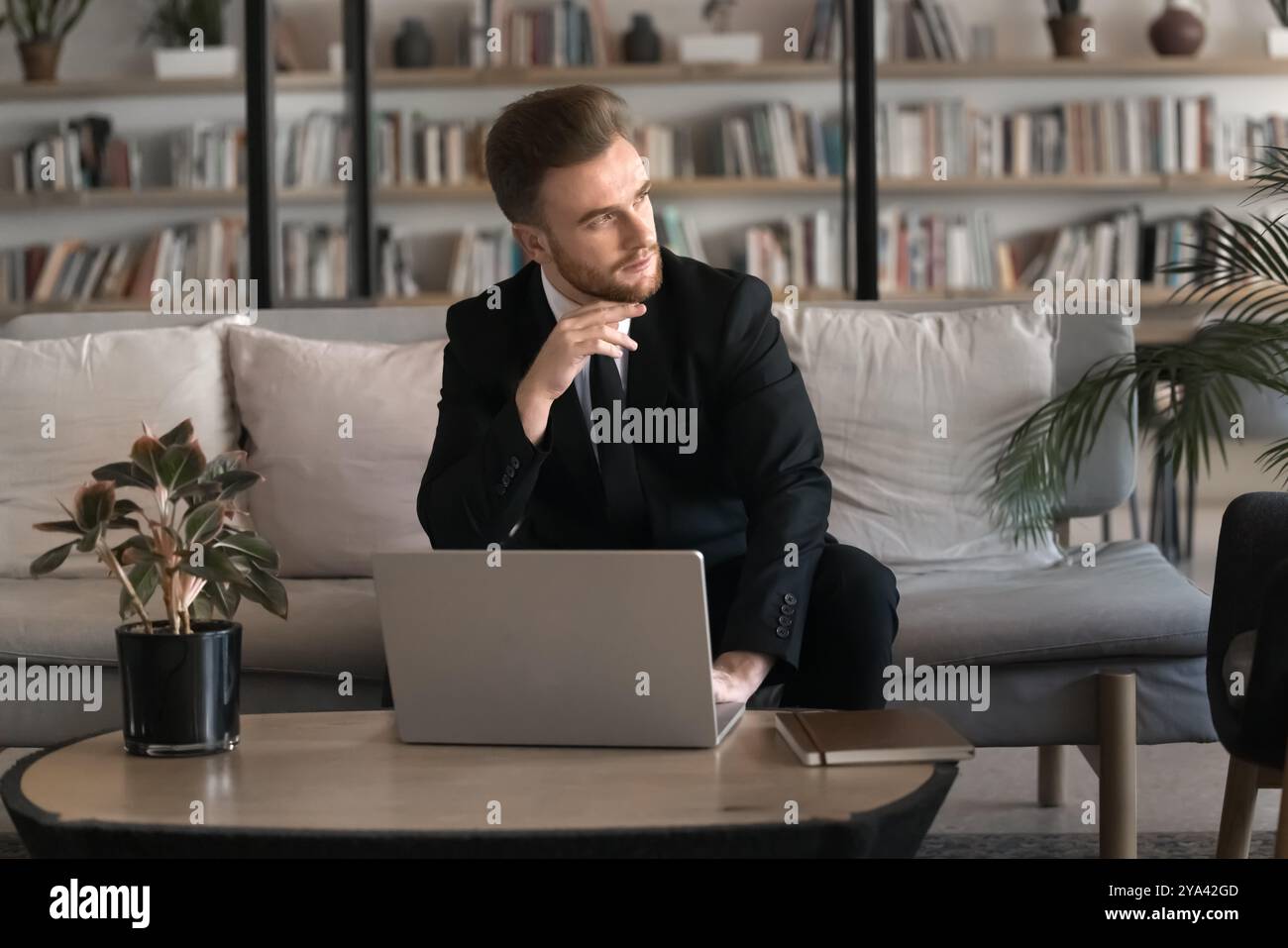 Thoughtful serious business professional man in formal suit using ...