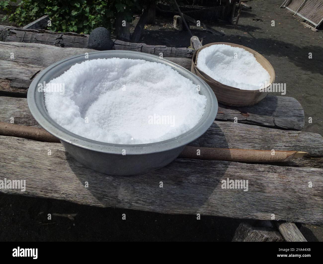 Traditional sea salt production by a salt farmer on the black lava ...