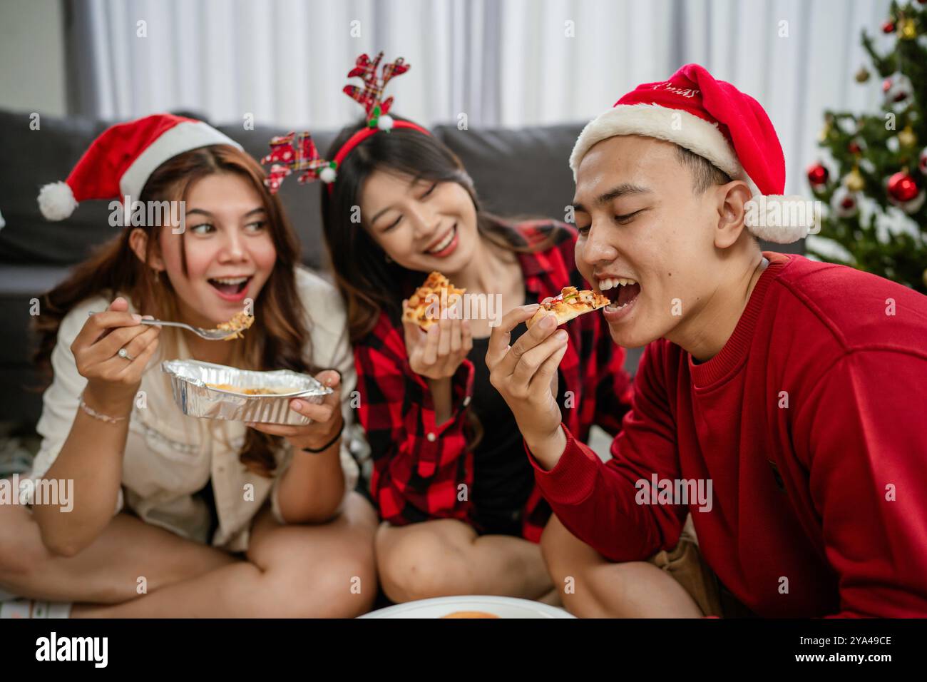 asian male eating pizza christmas party Stock Photo - Alamy