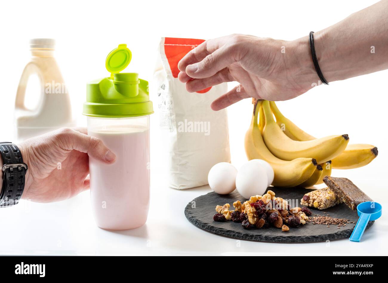 Shaker in hands. Making a milkshake. Cocktail with bananas and dried ...