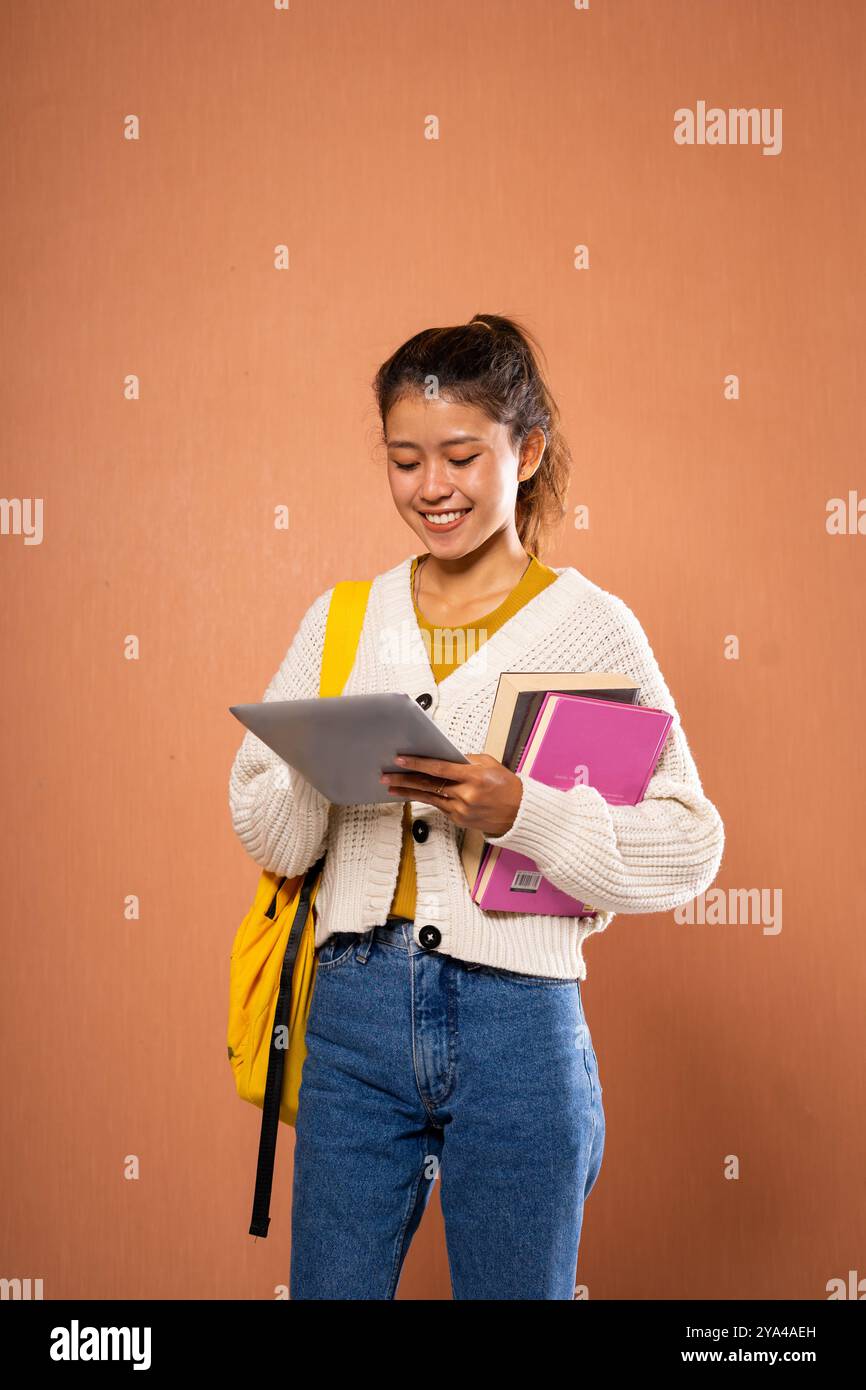 A Cheerful Student Holding a Tablet and Books in a Vibrant, Warm ...