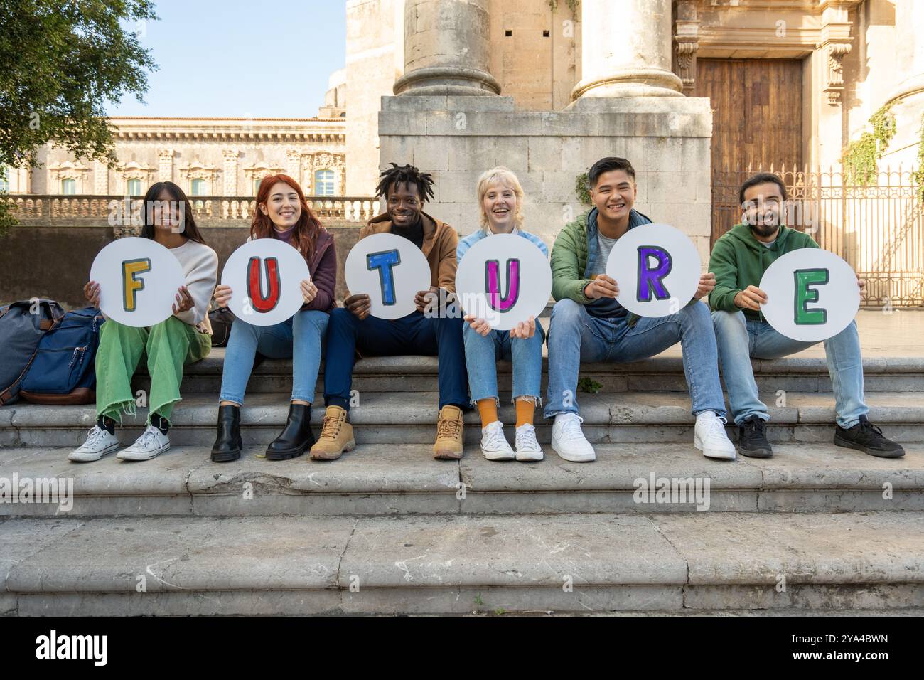 Cheerful diverse group of students holding handwritten 'FUTURE' signs ...