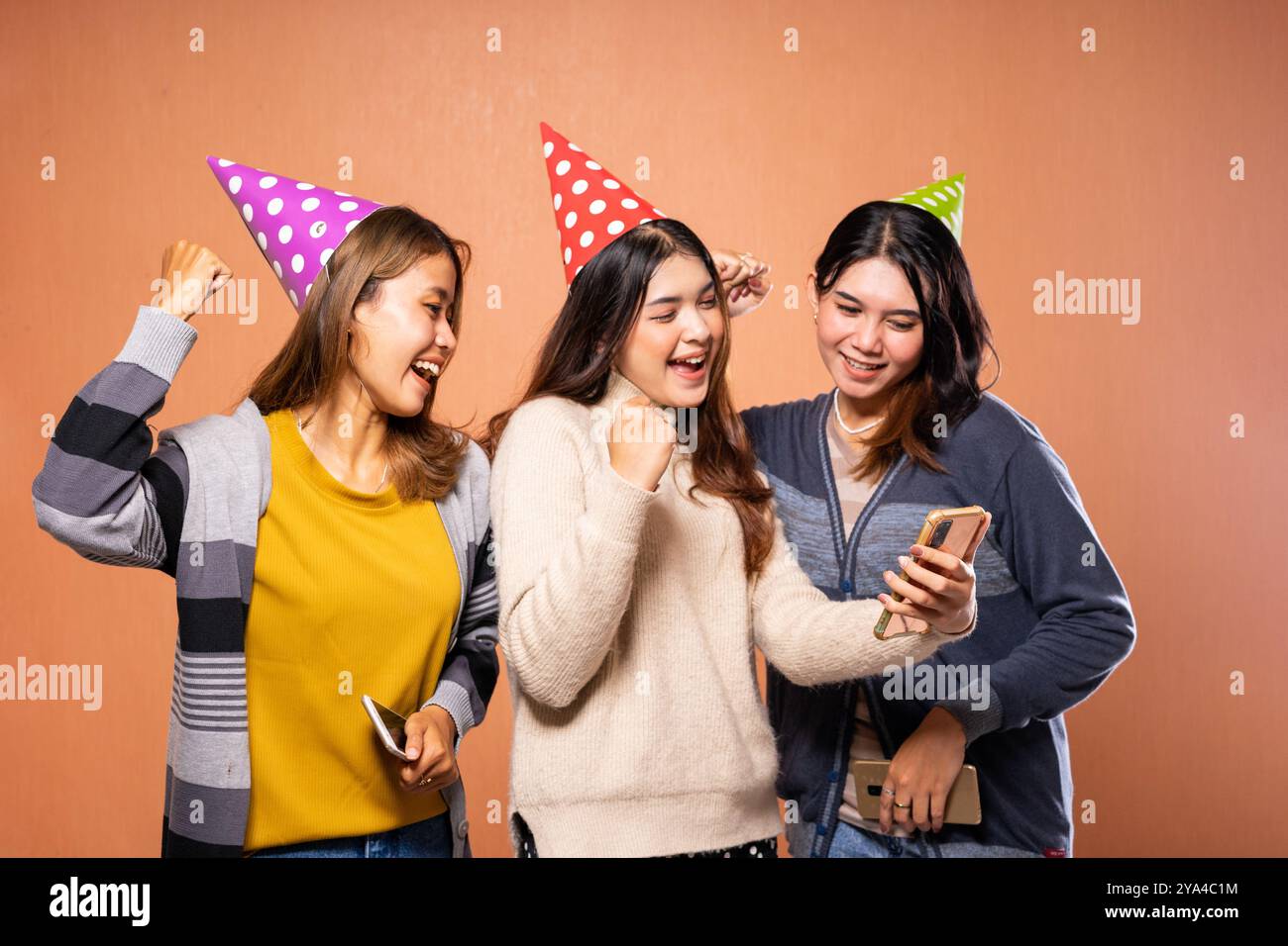 Three Friends Joyfully Celebrating Together with Colorful Party Hats ...